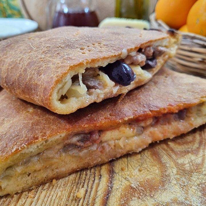 Cudduruni siciliano con cipolle, salsiccia, primo sale e olive